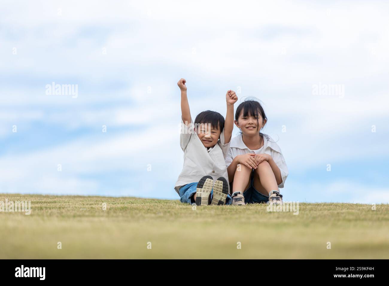 Children sitting close together in grassland Stock Photo - Alamy