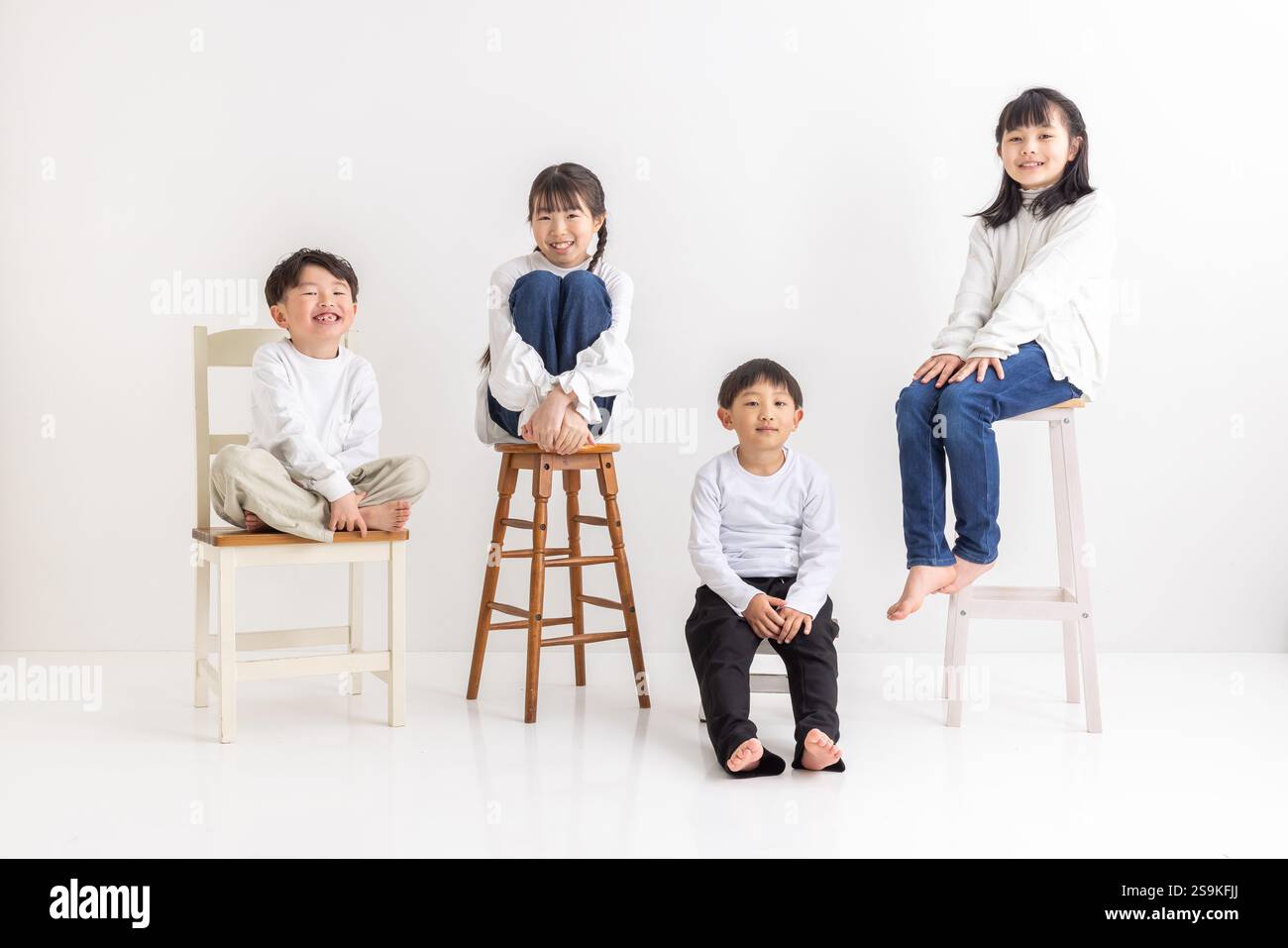 Smiling children sitting on chairs smiling children Stock Photo - Alamy