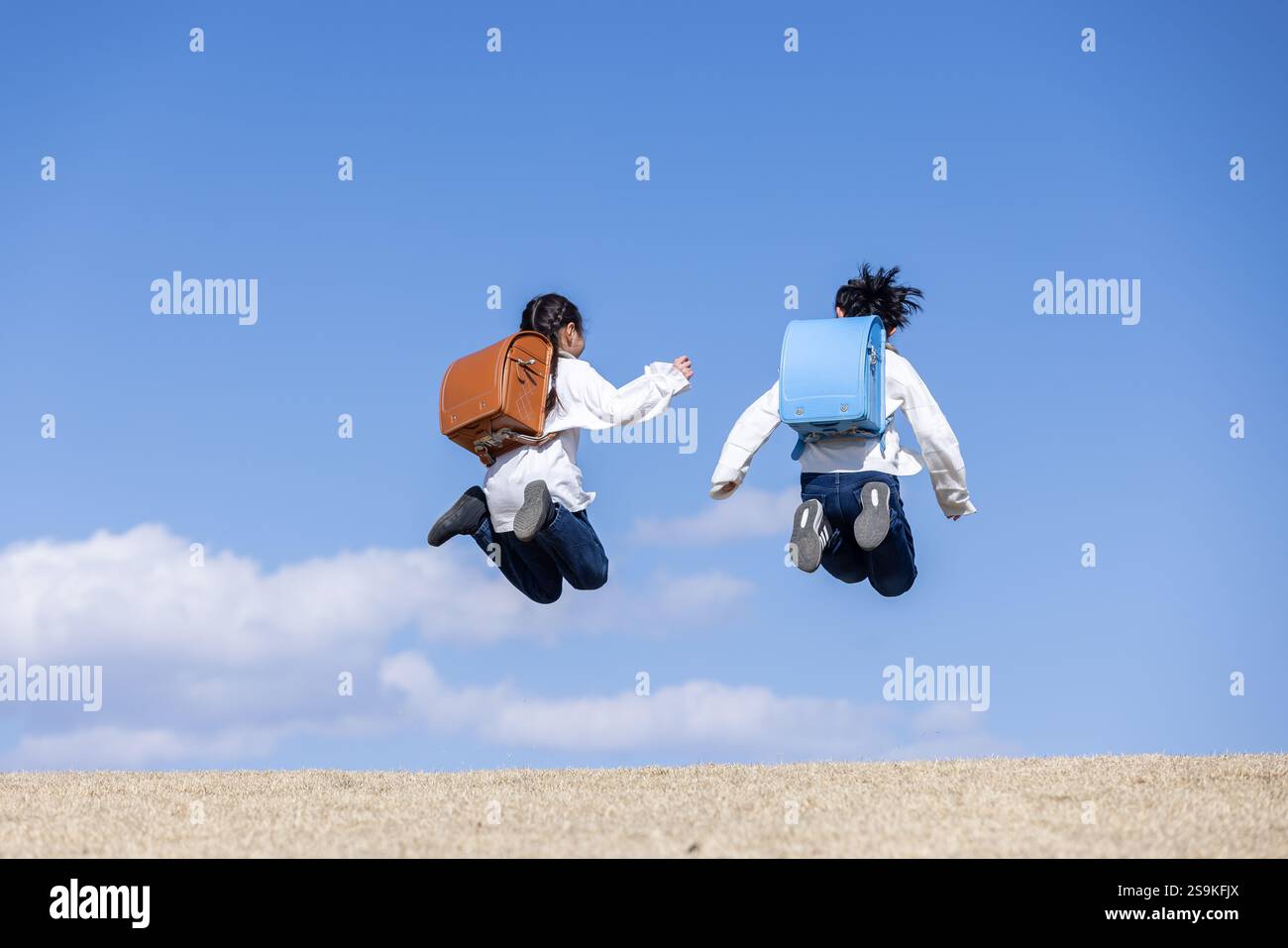 Primary schools student jumping in blue sky JUMP Stock Photo - Alamy