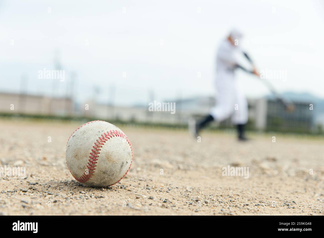 Baseball ball rolling on the ground Stock Photo - Alamy