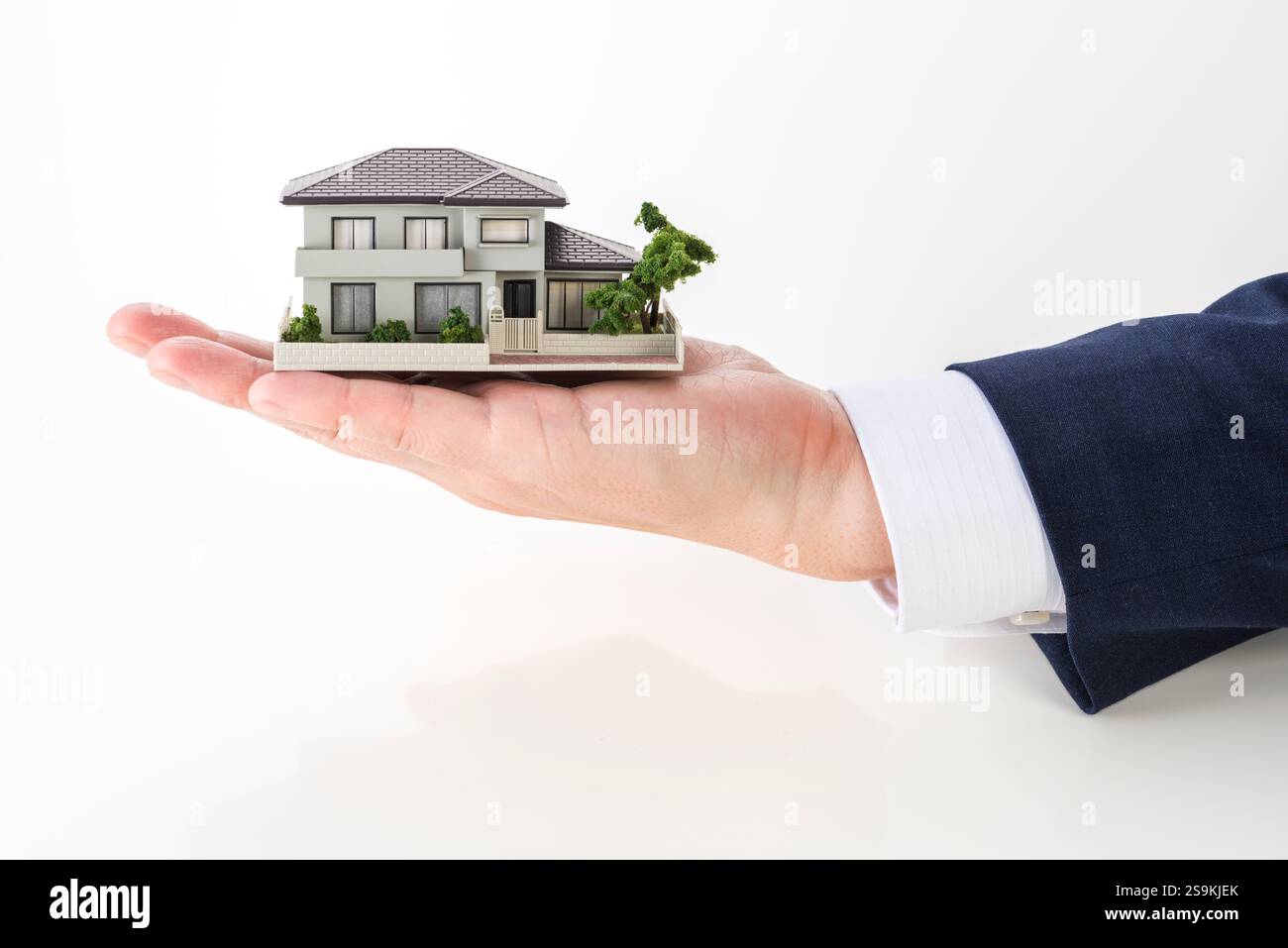 Salesman with a model of a house Stock Photo - Alamy