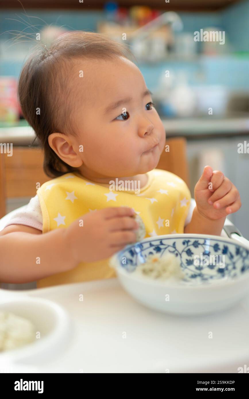Child eating a rice ball Stock Photo - Alamy
