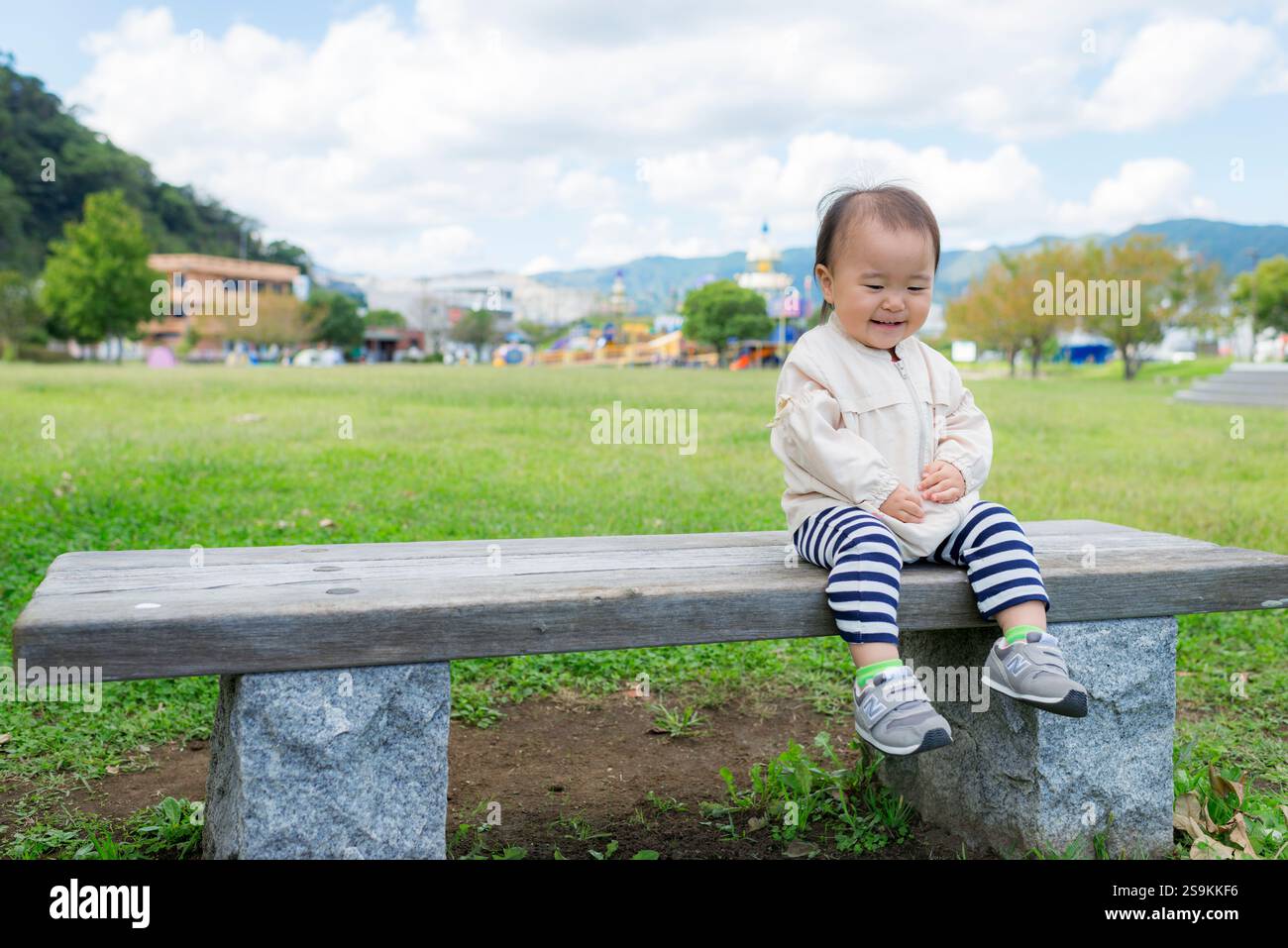 Child sitting on park bench Stock Photo - Alamy