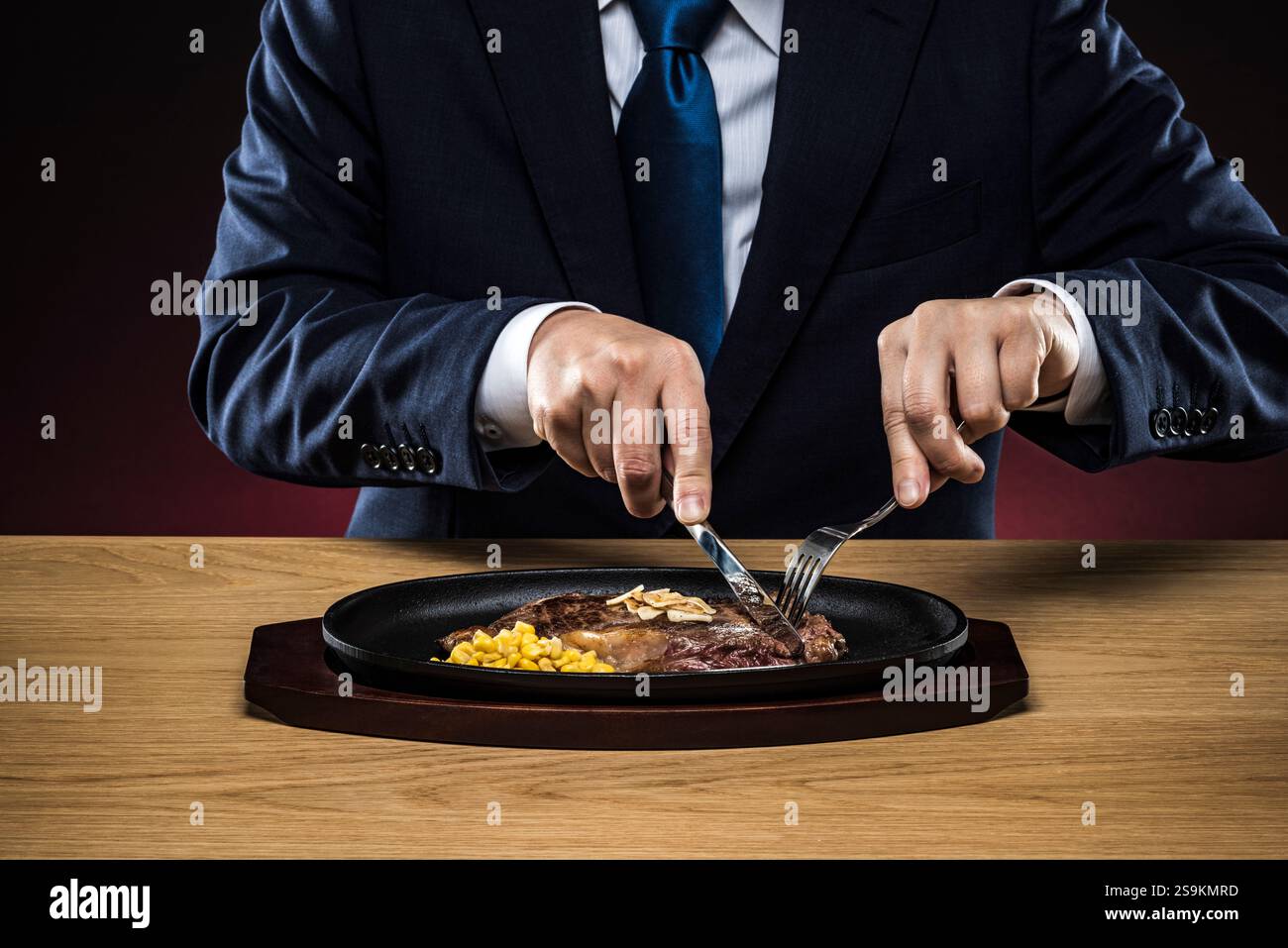 Man in suit eating steak Stock Photo - Alamy