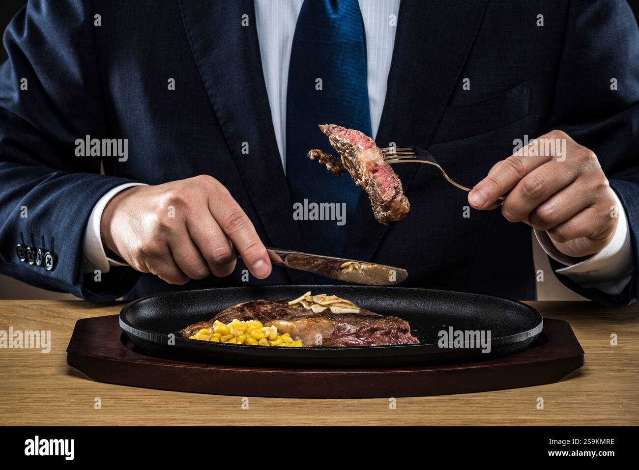 Man in suit eating steak Stock Photo - Alamy