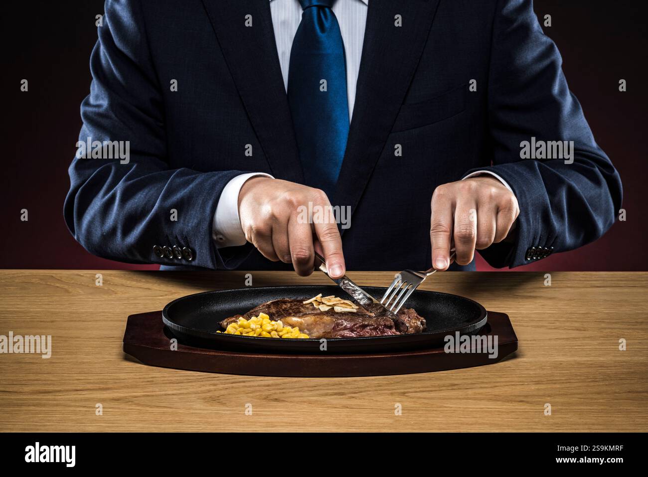 Man in suit eating steak Stock Photo - Alamy