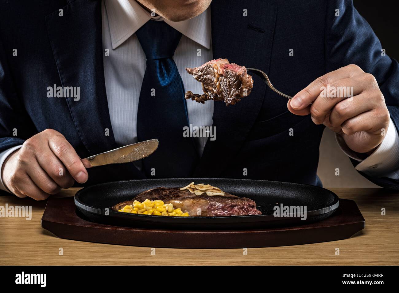 Man in suit eating steak Stock Photo - Alamy