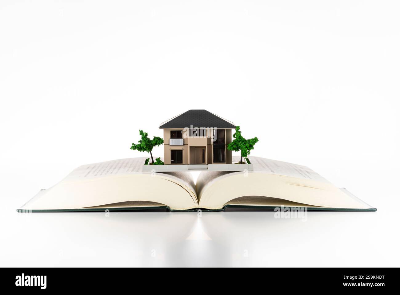 Open book and miniature detached house Stock Photo - Alamy