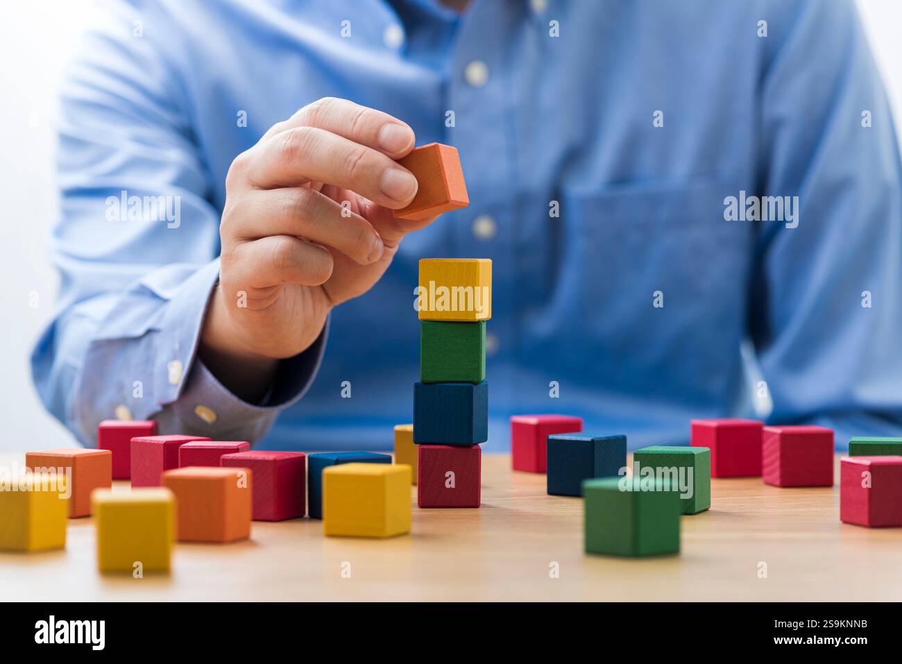 Stacking colourful blocks People Stock Photo - Alamy