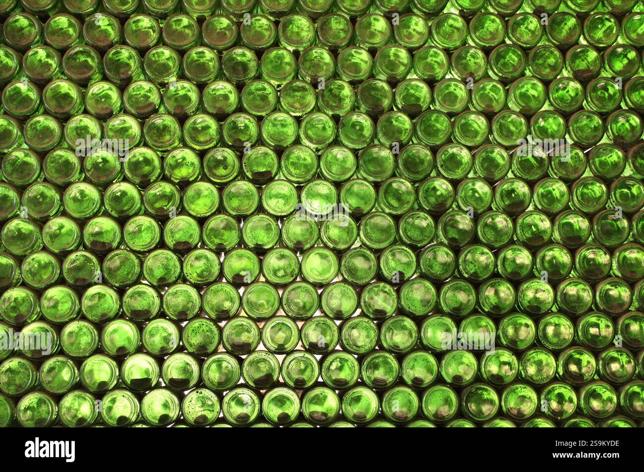 Full frame wall with empty green beer bottles bottoms. Alcohol theme ...