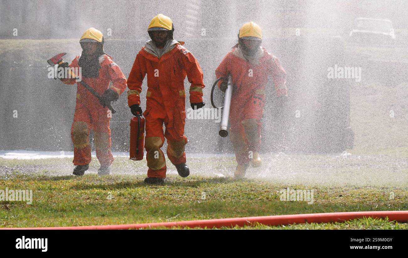 Firefighter fighting with flame using fire hose chemical water foam ...