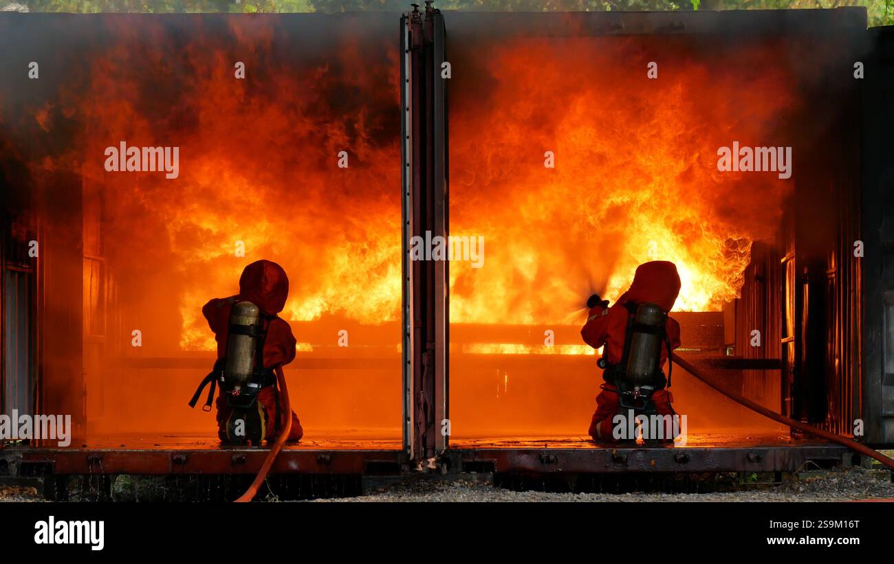 Firefighter fighting with flame using fire hose chemical water foam ...