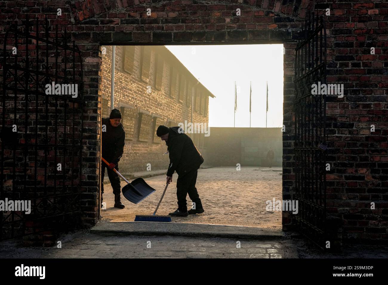 Men clean up ahead of the ceremony, backdropped by the Death Wall at ...