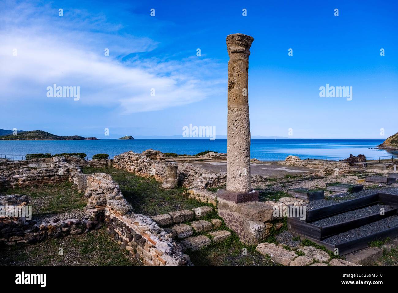Ruins and a stone pillar in the archaeological site of Nora, an ancient ...