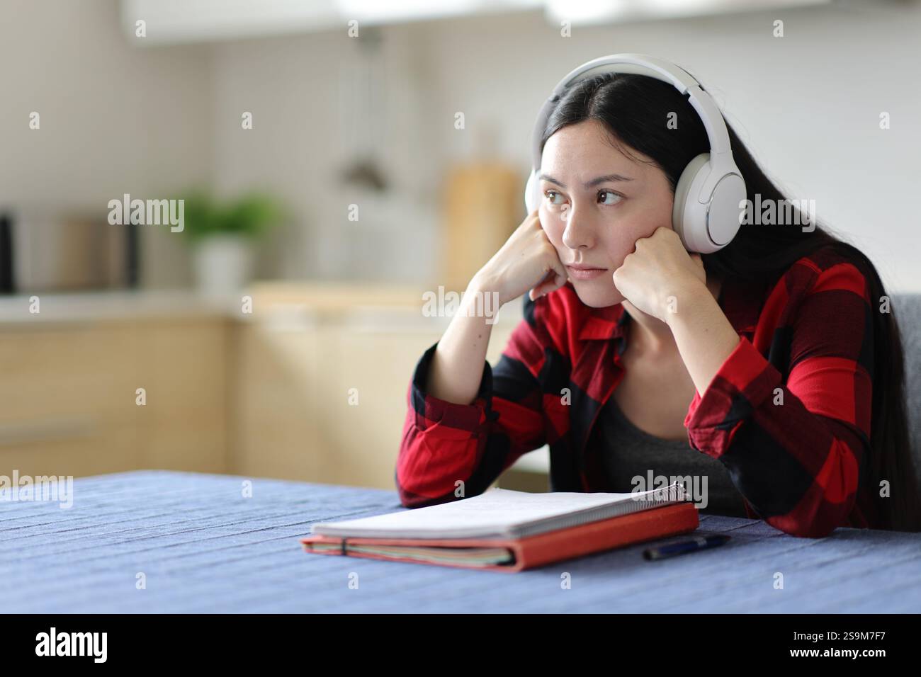 Distracted asian student listening audio tutorial with headphone in the ...