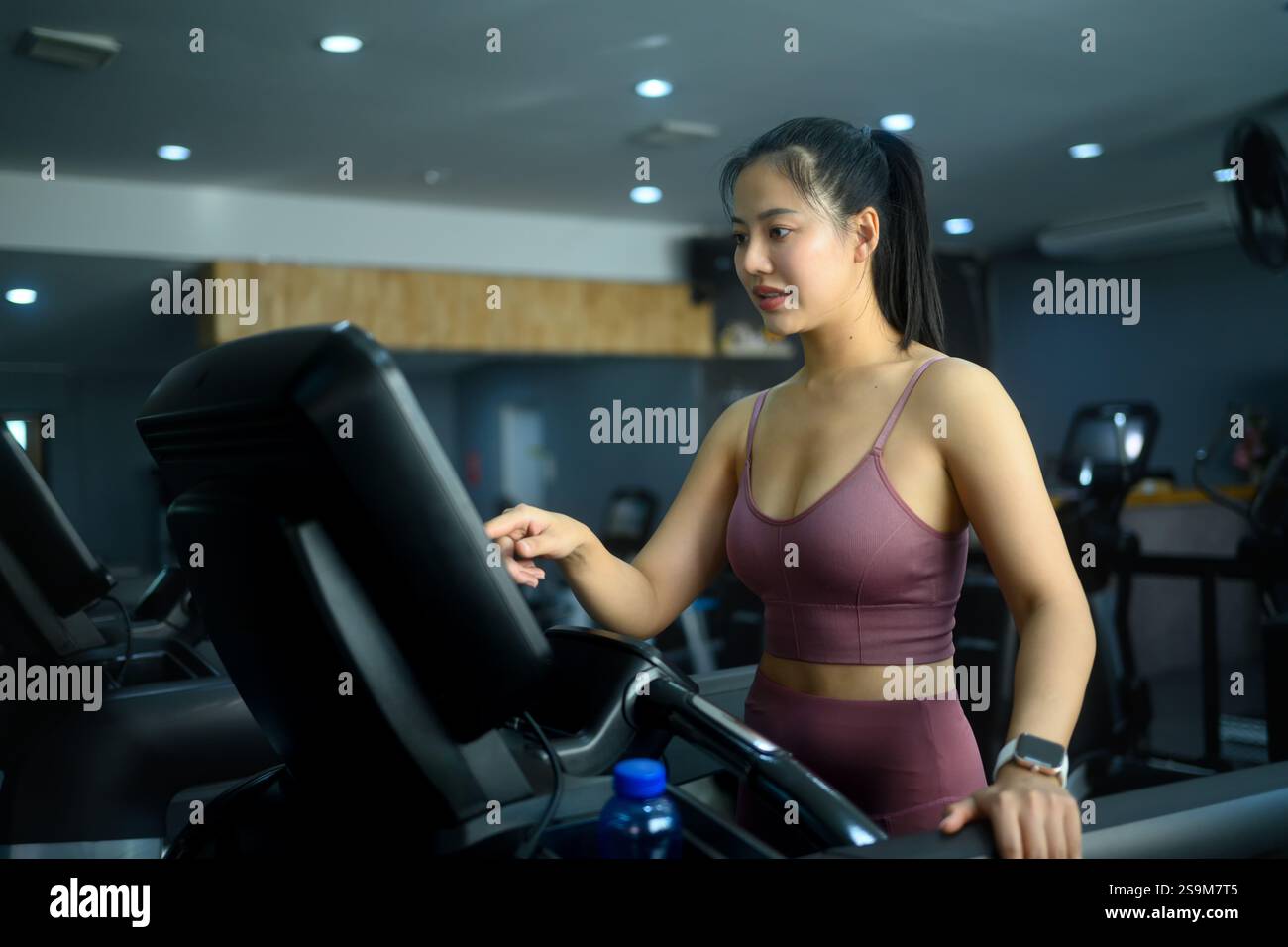 Woman adjusts treadmill settings in hi-res stock photography and images ...