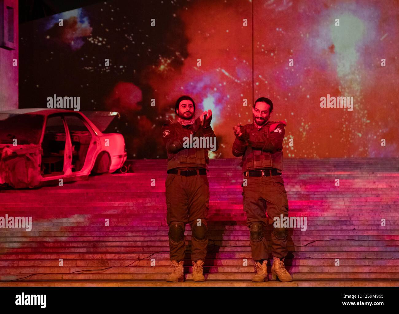 Two Iranian actors clap after performing as Israeli soldiers in an anti ...
