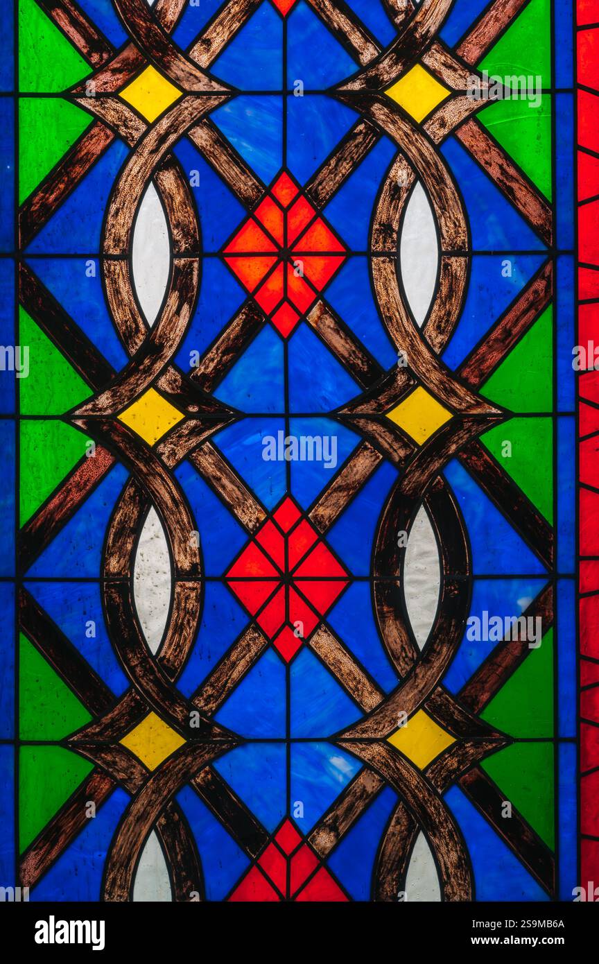A detail of a multi-colored panel from a stained glass window in a ...