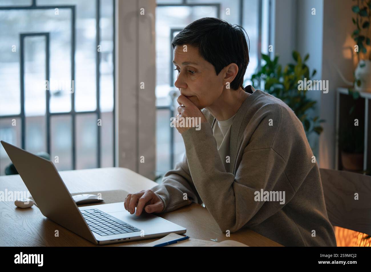 Tired woman overwhelmed by responsibilities, scrolling touchpad while ...