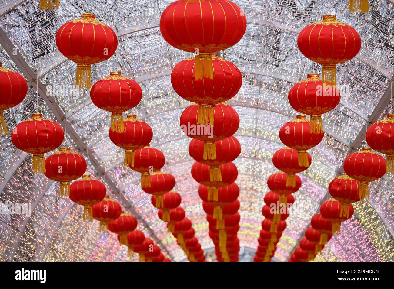 Red Chinese lanterns and festive lights in a row on a street. New Year ...