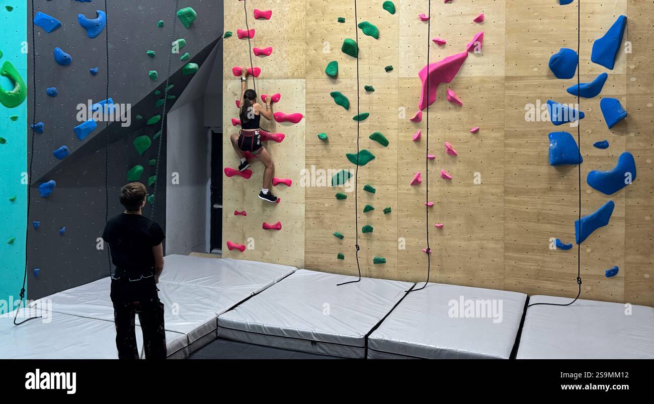 Teenage girl at indoor climbing wall. Kid having fun at bouldering wall ...