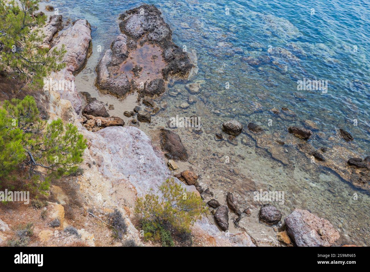 Serene View Of Greece's Rocky Shoreline With Crystal-clear Water ...