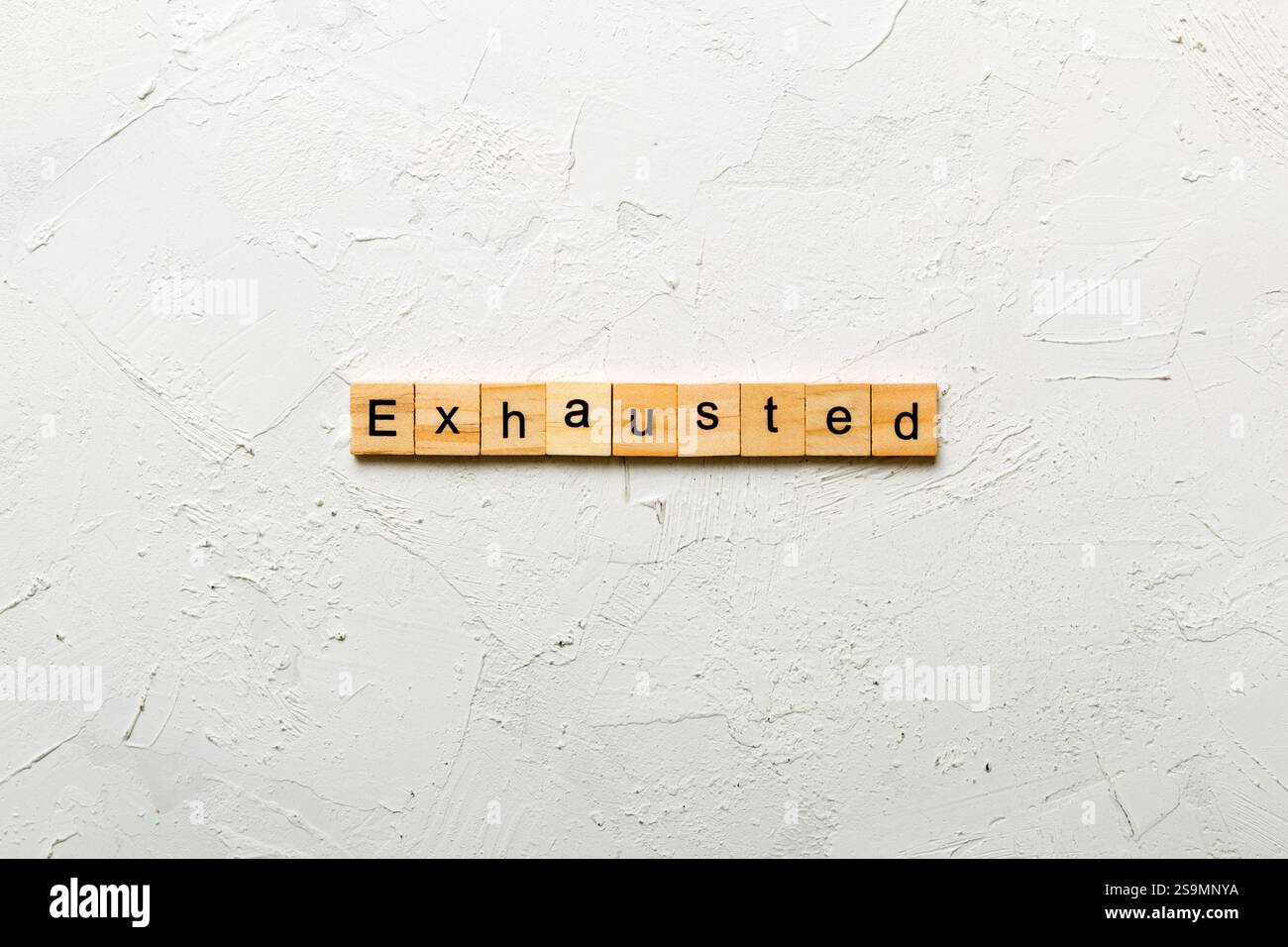 Exhausted word written on wood block. Exhausted text on cement table ...