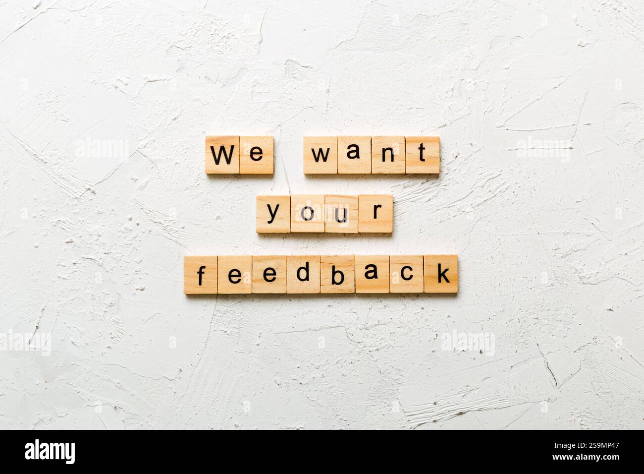 We want your feedback word written on wood block. We want your feedback ...