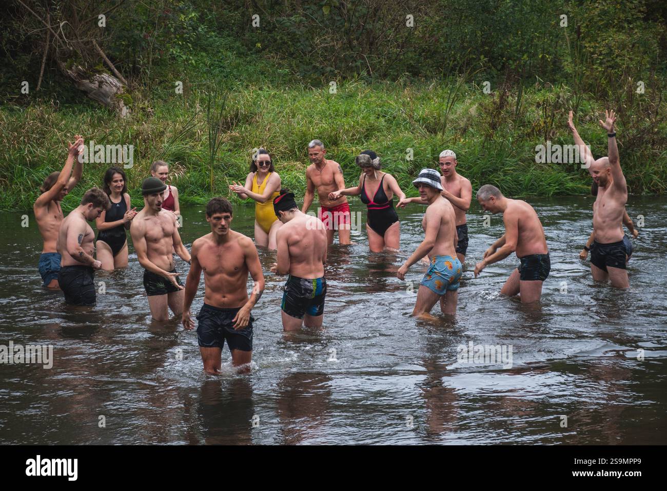 Group of people in circle ice bathing together in the cold water of a ...