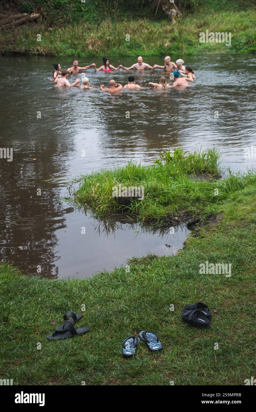 Group of people in circle ice bathing together in the cold water of a ...