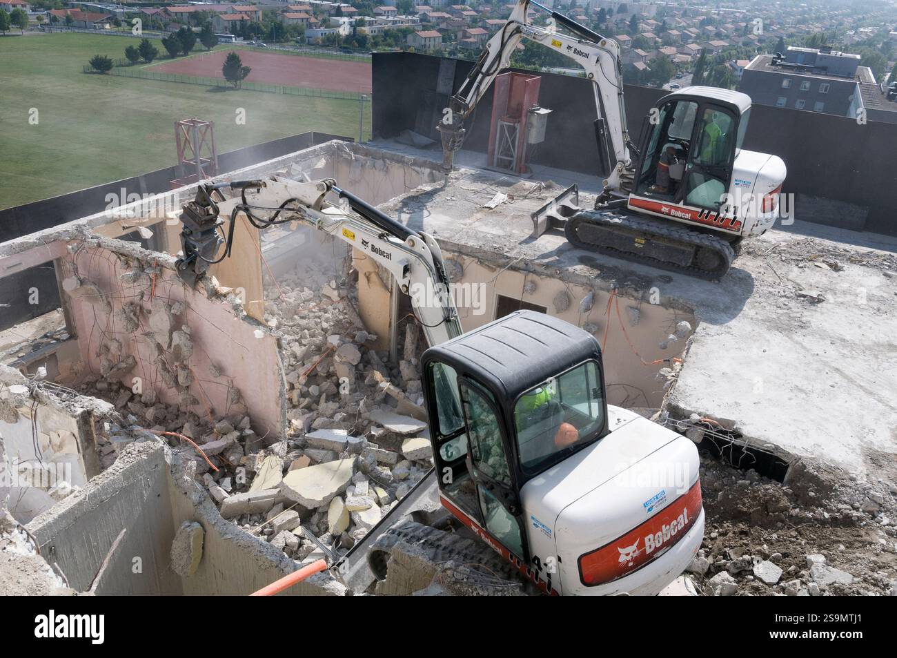 Two BOBCAT mini-excavators busy destroying a building Stock Photo - Alamy