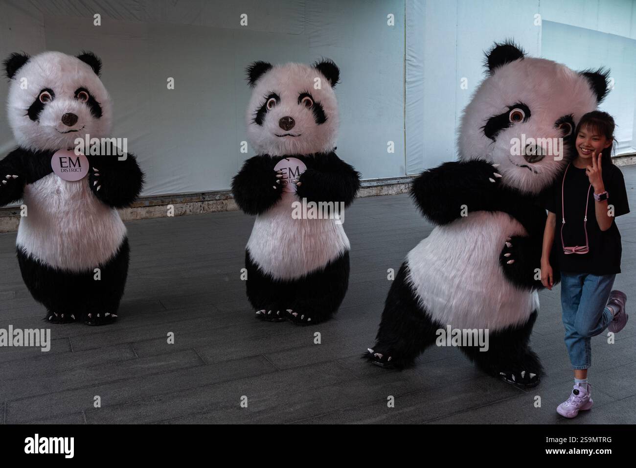 A kid poses for a photo with Panda mascots in front of the shopping ...