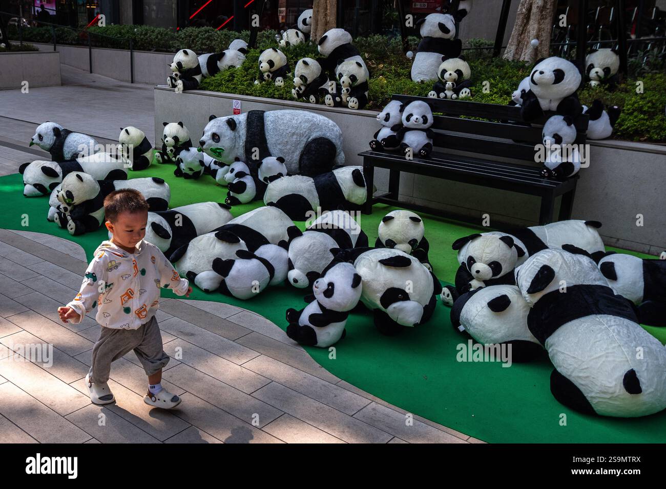A kid walks past the panda sculpture installations at the shopping mall ...