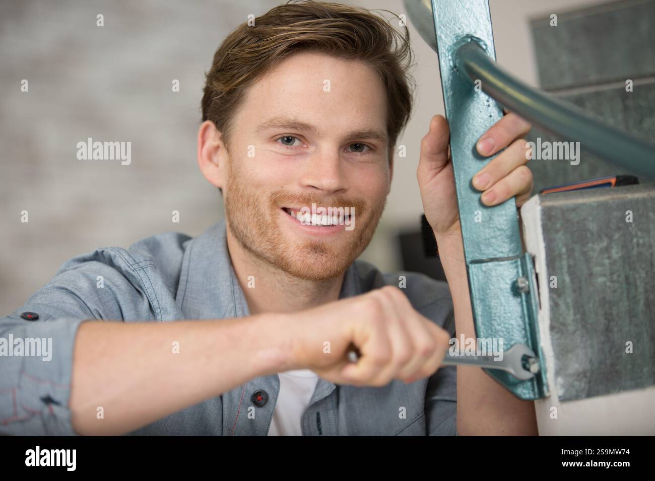 handsome man using a screw driver indoors Stock Photo - Alamy