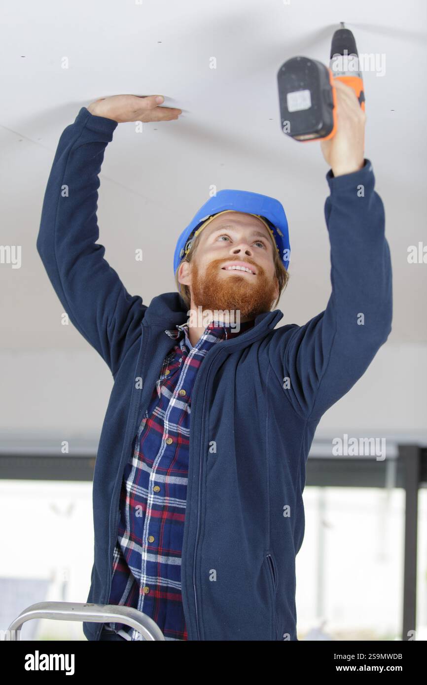 manual worker drilling ceiling with a drilling machine Stock Photo - Alamy