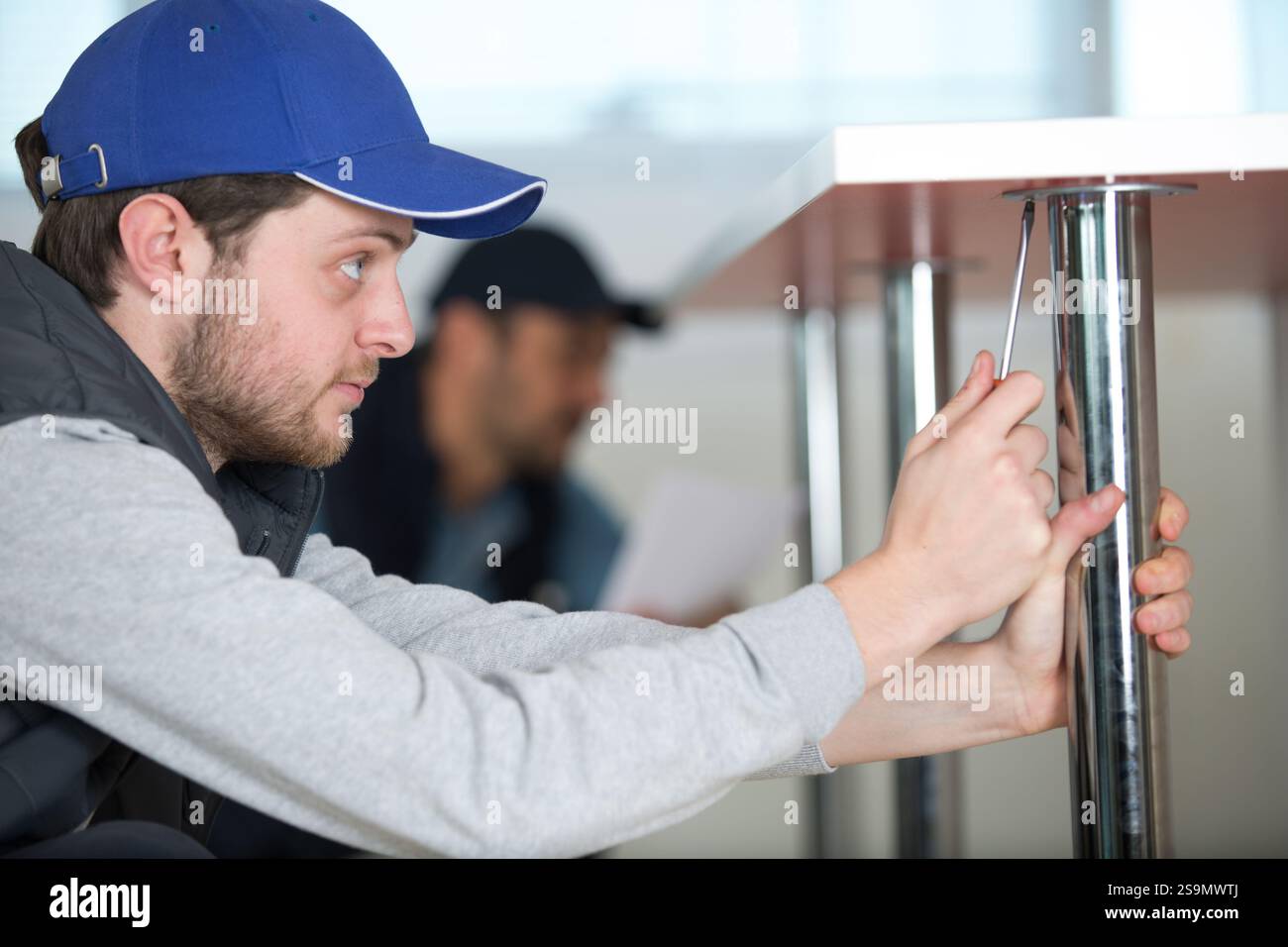 young man while doing fittings to chipboard Stock Photo - Alamy