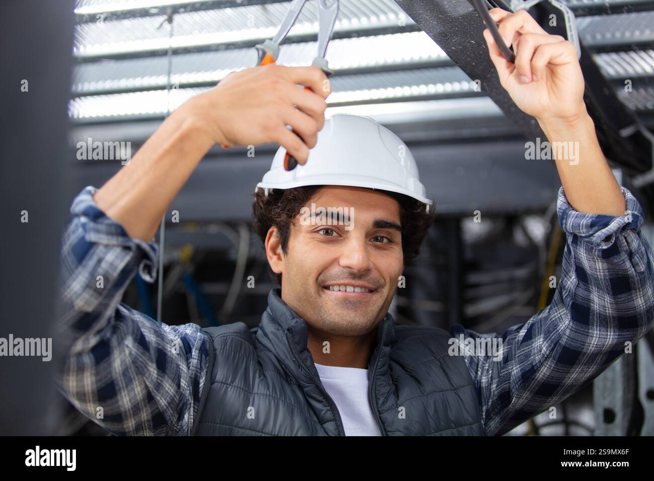 young builder replacing ceiling panel Stock Photo - Alamy