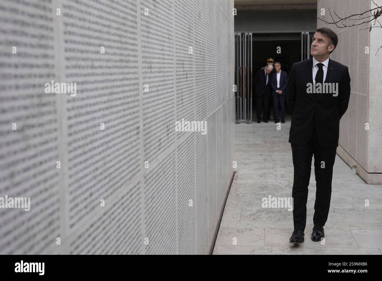 French President Emmanuel Macron walks past the wall of names during ...