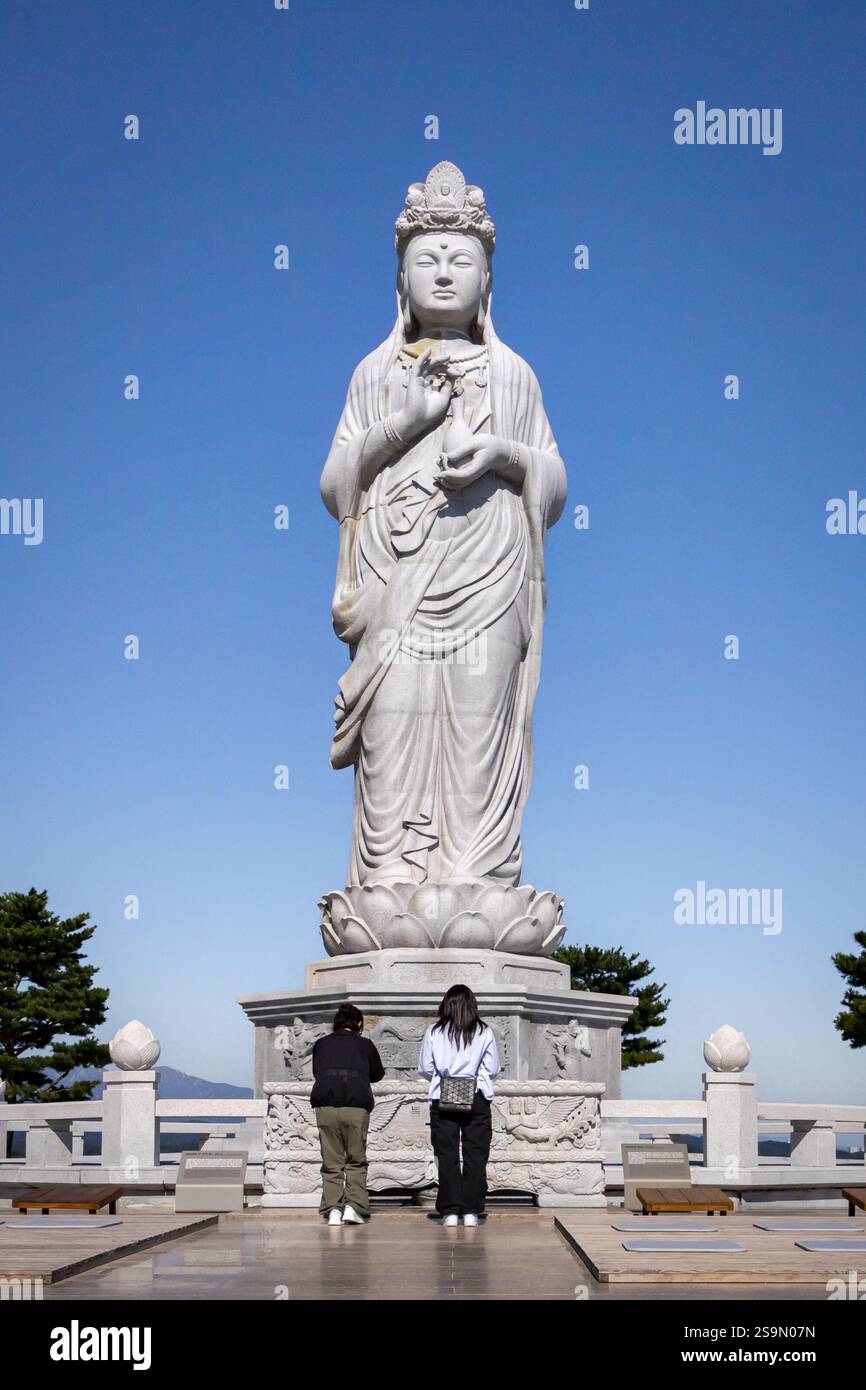 People praying and worshipping a giant standing Buddha statue. Photo ...