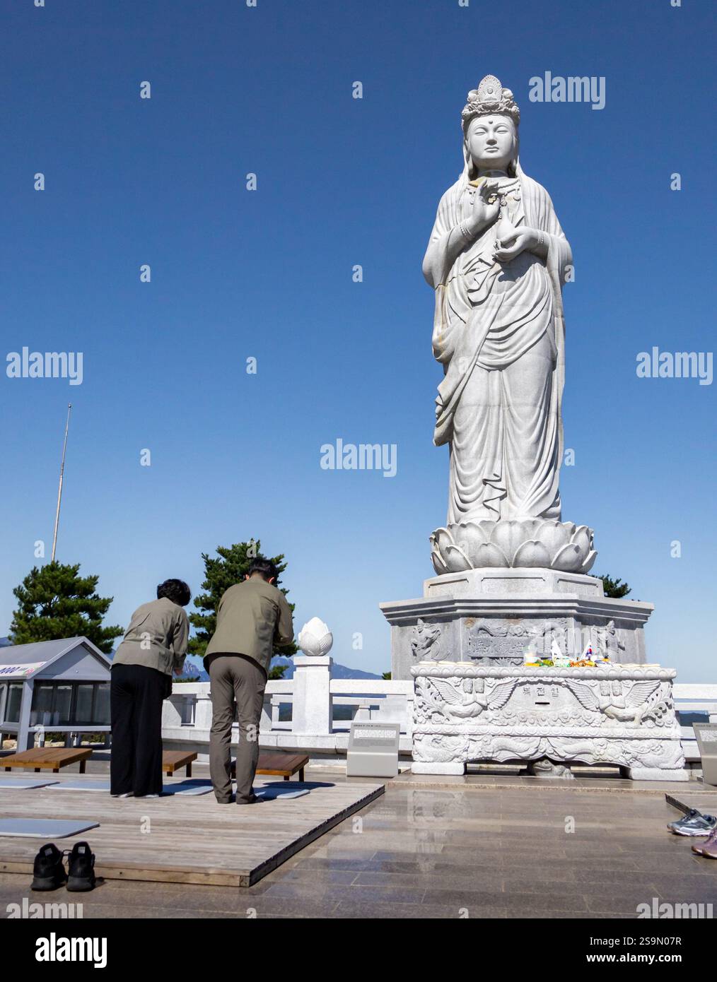 People praying and worshipping a giant standing Buddha statue. Photo ...