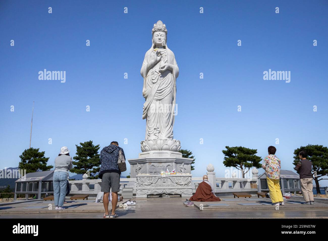 People praying and worshipping a giant standing Buddha statue. Photo ...