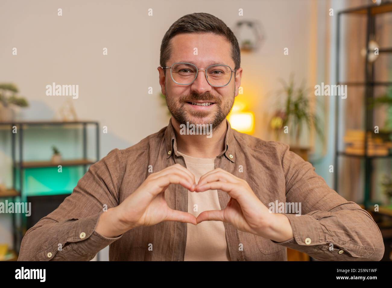 I love you. Caucasian young businessman makes symbol of love, showing ...