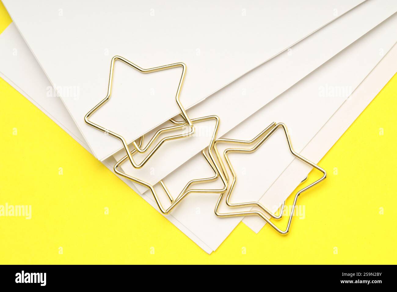 Star shaped paper clips and notes on yellow background, top view Stock ...