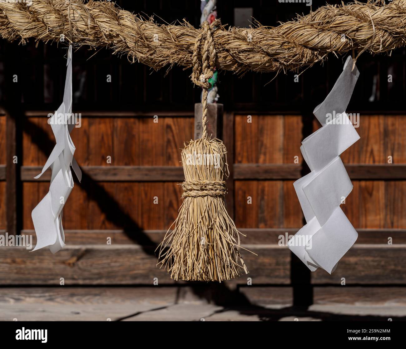 A rope (shimenawa) and paper streamers (shide) at a Shinto shrine in ...