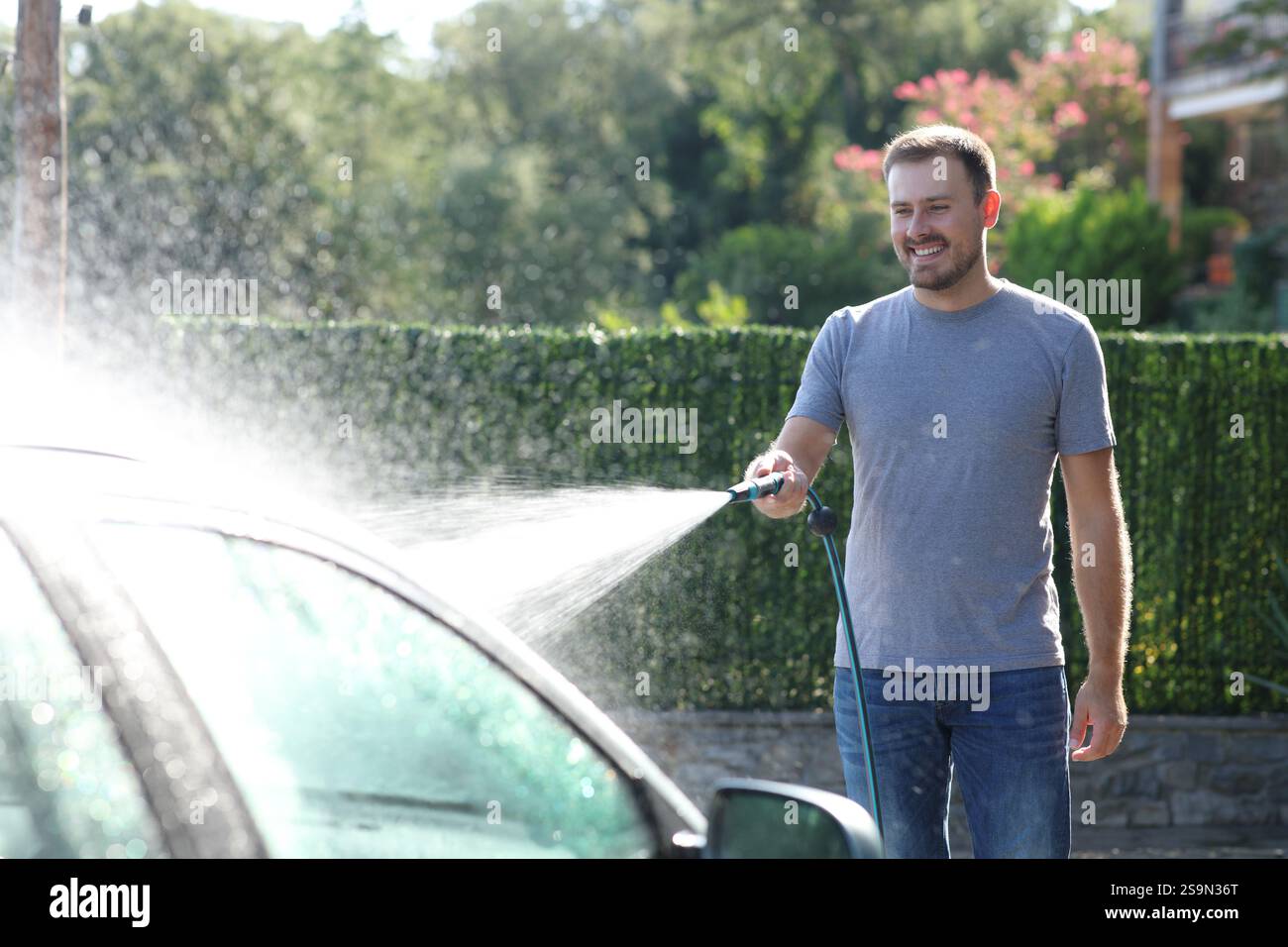 Happy man washing car in a garden at home Stock Photo - Alamy