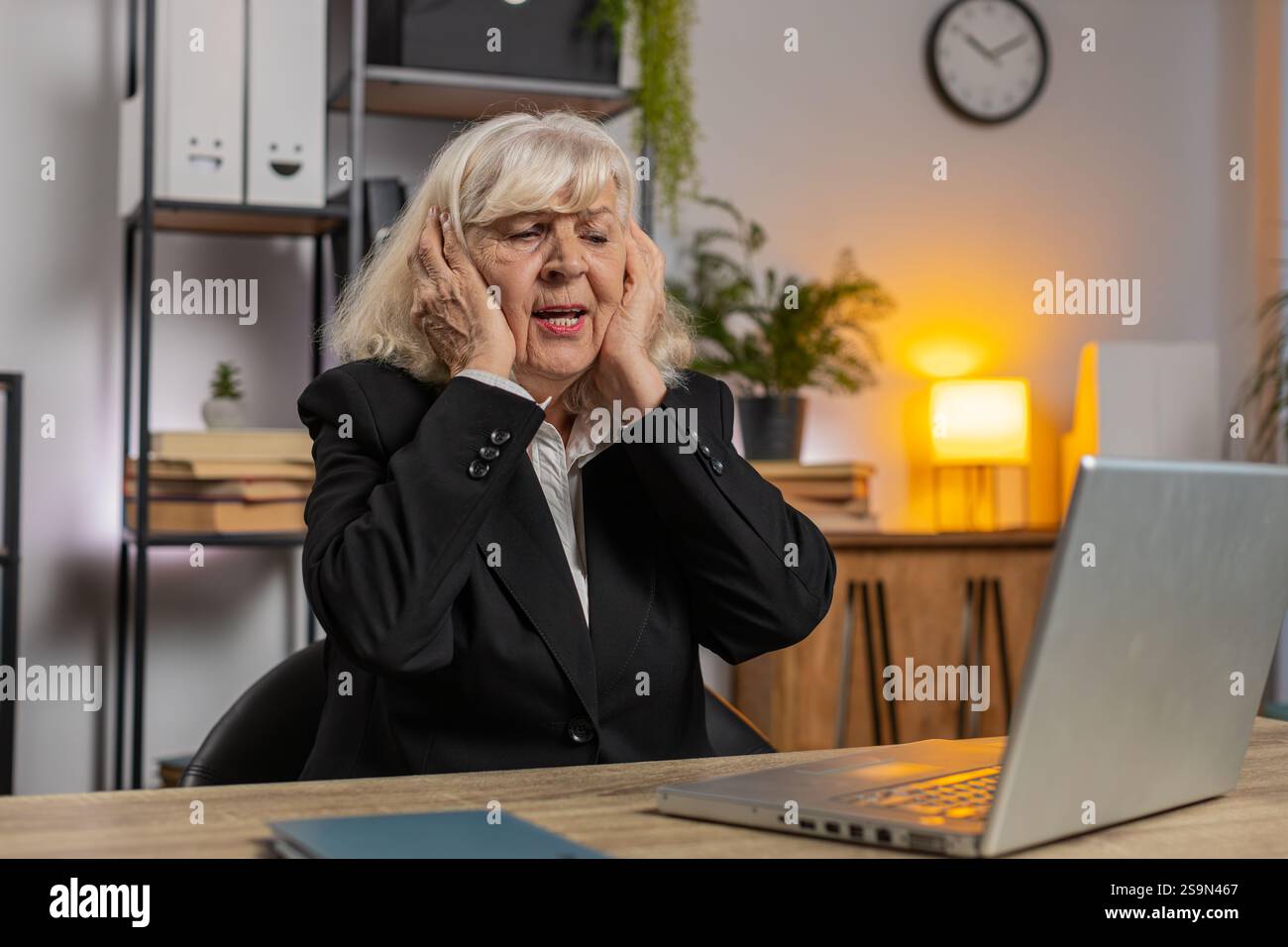 Angry furious elderly businesswoman freelancer using laptop working at ...