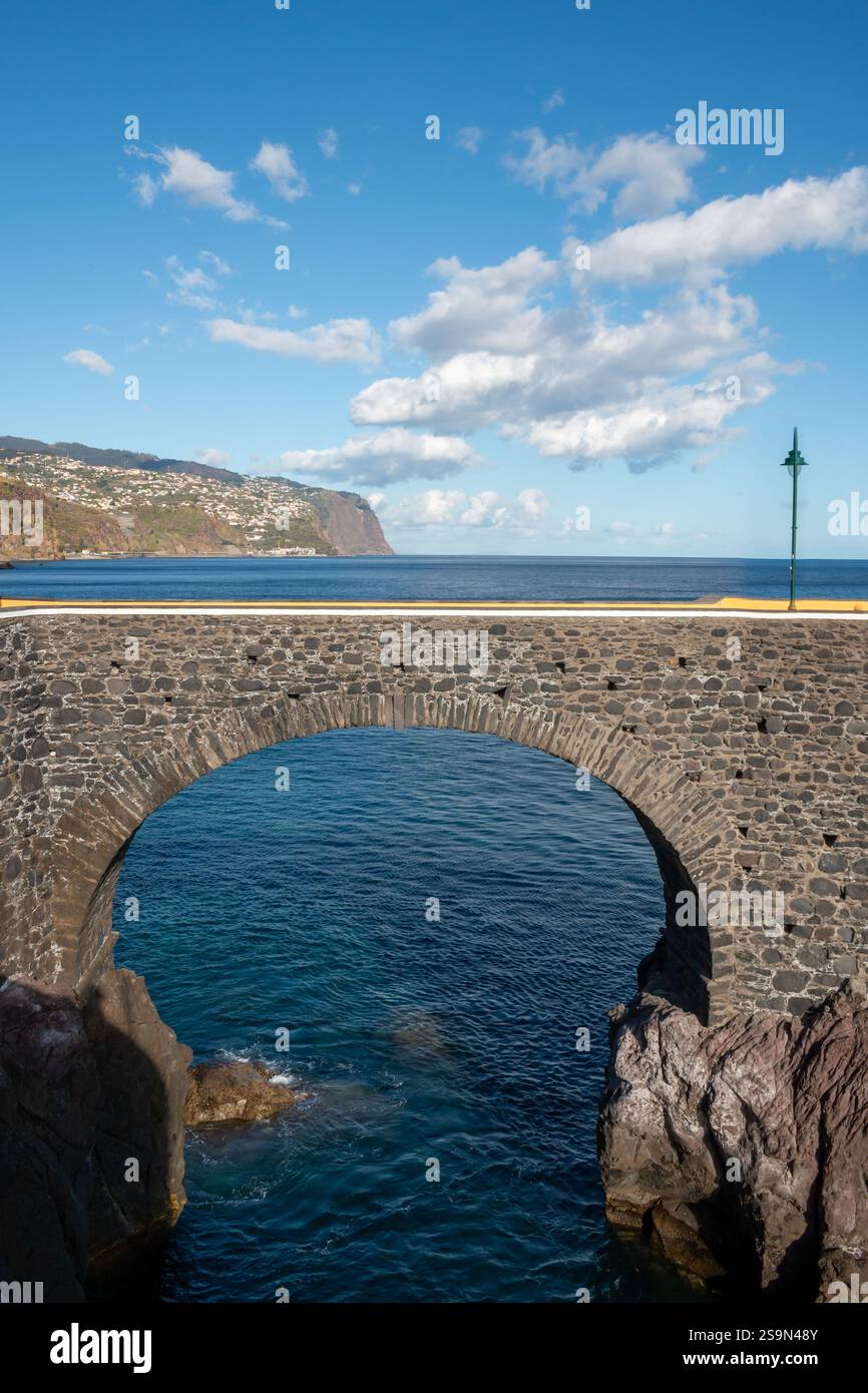 Stone bridge as a pier to the Atlantic ocean. Blue sky with white ...