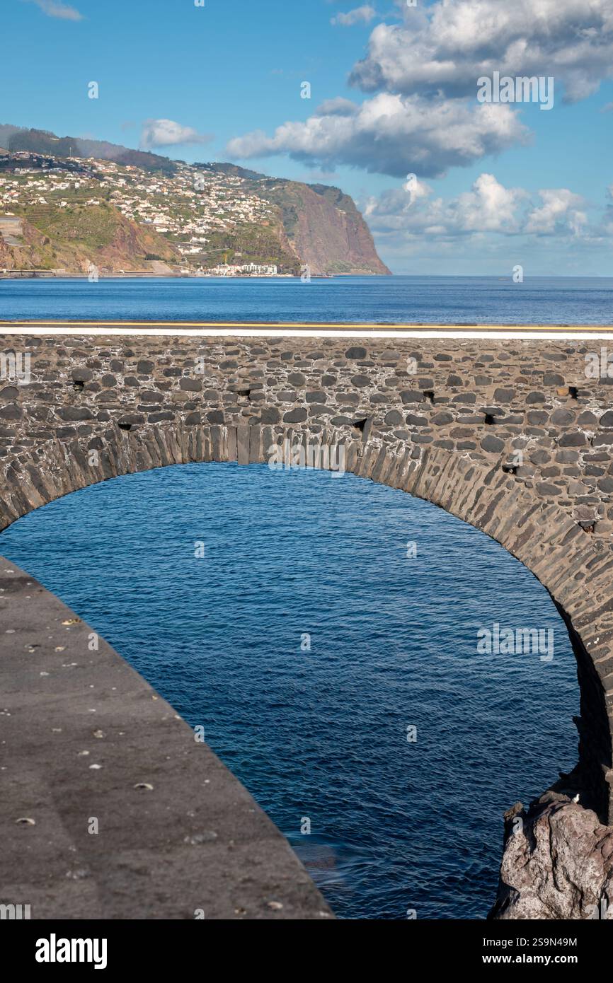 Stone bridge as a pier to the Atlantic ocean. Blue sky with white ...