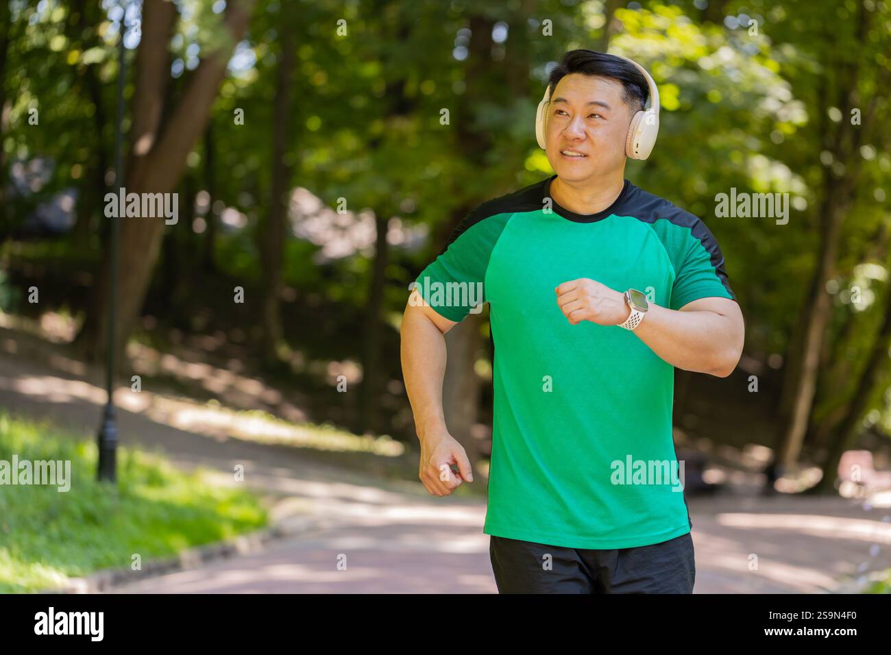Active sportsman jogging training marathon run, listening to music in ...