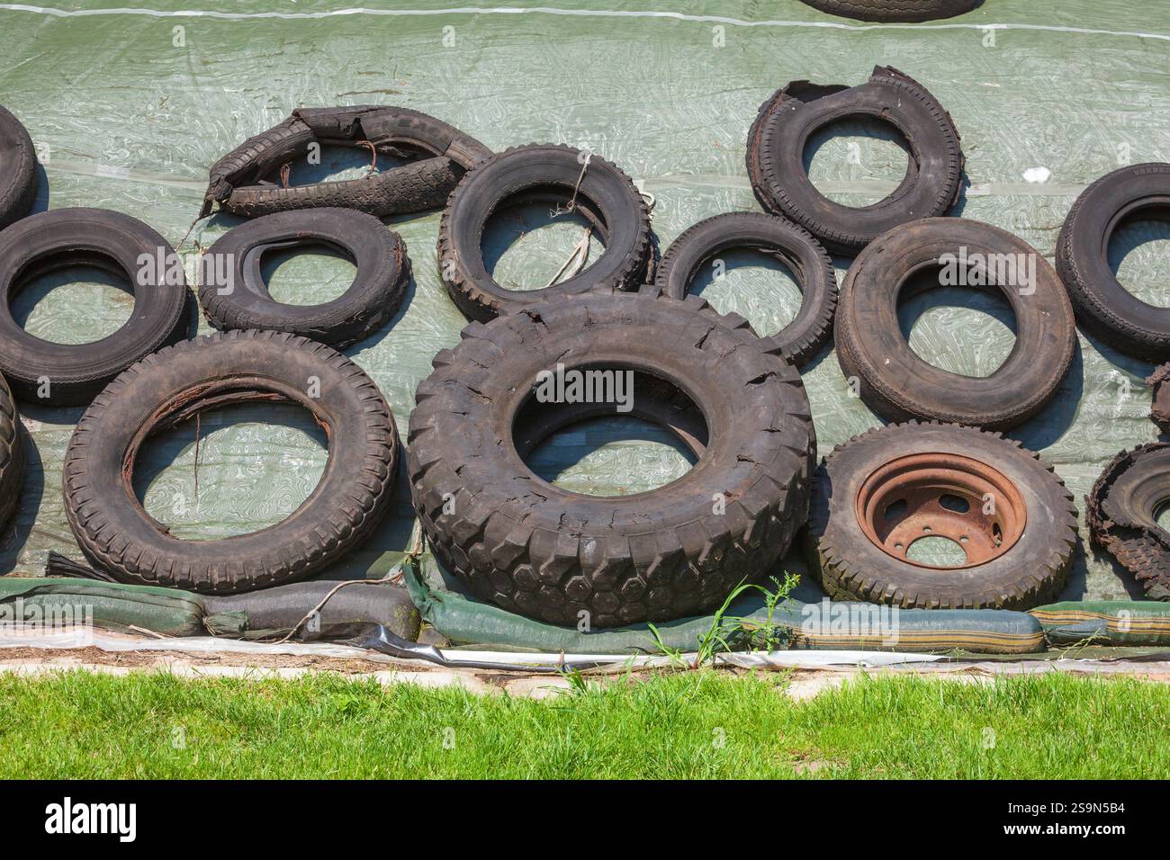 Used tires as a cover on a tarpaulin, Germany Stock Photo - Alamy